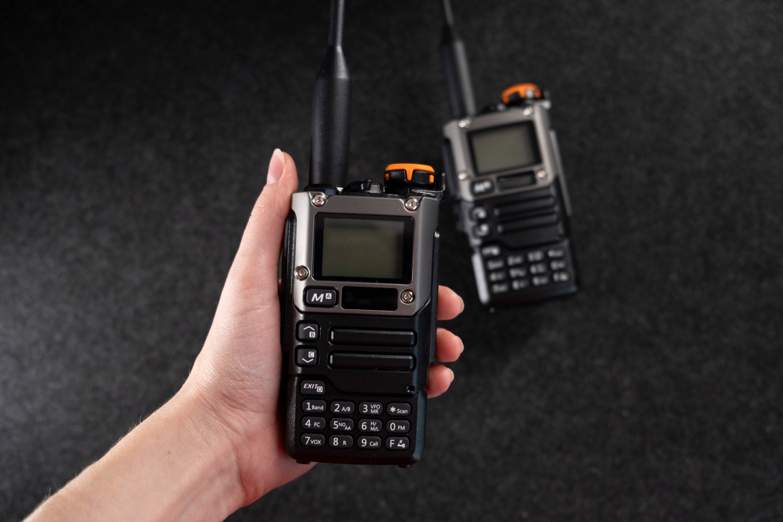 Two professional handheld radios with sleek black designs and antennas ...